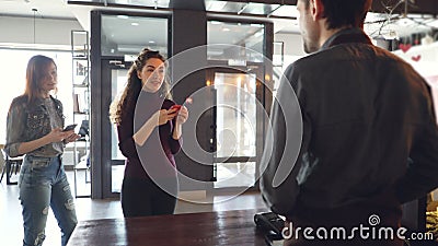 Cheerful Customer in Cafe is Making Payment with Smartphone while Queue ...