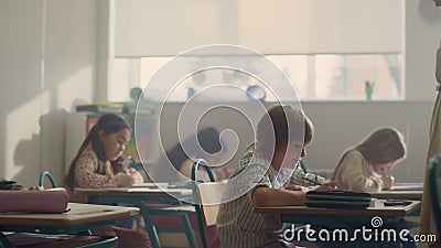 Children Doing Class Work at Desks. Teacher Explaining Lesson To Pupils ...