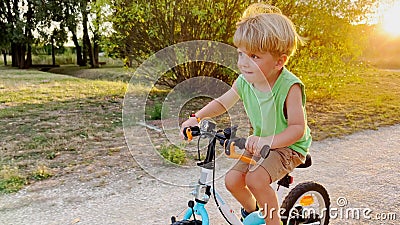 Close Shoot of a Handsome Blond Boy Ride Bicycle in Park Stock Footage ...