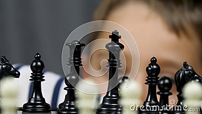 Close-up of Chess Pieces on the Board. a Brooding Child Looks through ...
