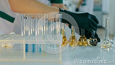 Close-up of Pouring a Yellow Chemical Solution into Test Tubes. Work in ...