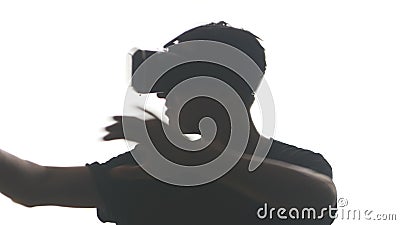 Silhouette of a Young Man in Headphones Getting Experience in Using VR ...