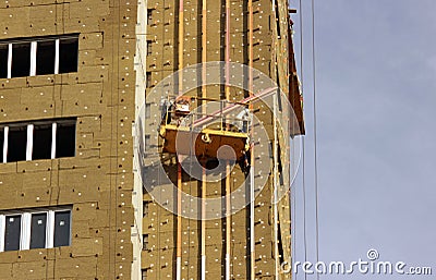 Construction Suspended Yellow Cradle With Workers On A Newly Built High ...
