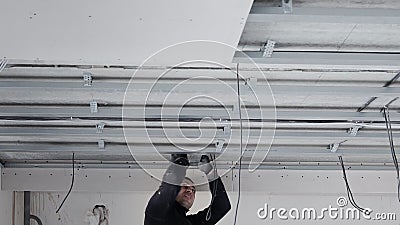 Construction Worker Assemble a Suspended Ceiling with Drywall and ...