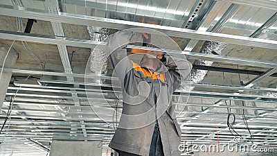 A Construction Worker Assembles Metal Suspended Ceiling Structures ...