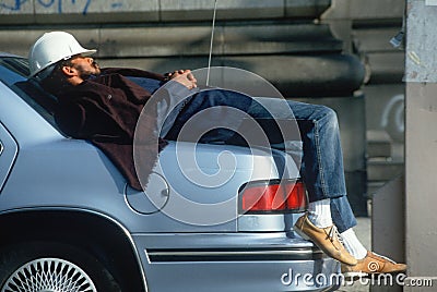 A construction worker resting on his car, - Stock Image - Everypixel