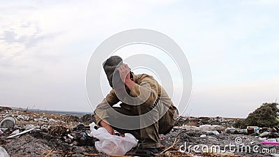Dirty Homeless Man Sits on the Trash and Eat Bread Stock Footage ...