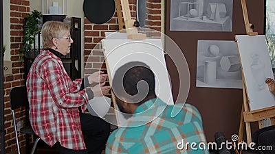 Elder Teacher Explaining Drawing Technique To Students in Art Class ...