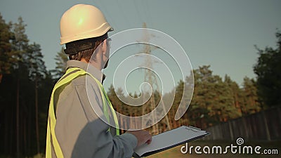 Electrical Engineer Looks at an Electrical Tower, Wearing Protective ...