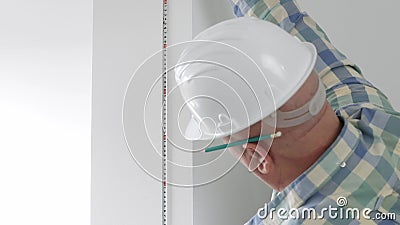 Engineer Working in a Construction Site, Using a Tape Measure for ...