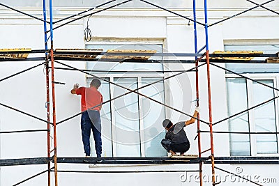 Facade Restoration. Plasterers Work While Standing On The Scaffolding ...