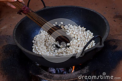 Frying Grains Of Maze With A Traditional Bamboo Stick Royalty-Free ...