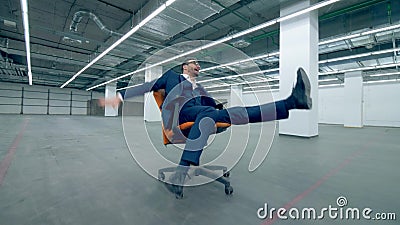 Gappy, Funny Office Manager is Riding on a Rolling Chair Across an ...