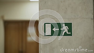 Sign Indicating Direction of Emergency Exit is Attached To Pole in the ...
