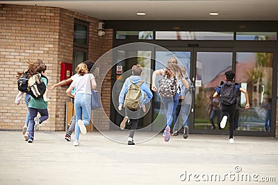 Group Of High School Students Running Into School Building At Beginning ...