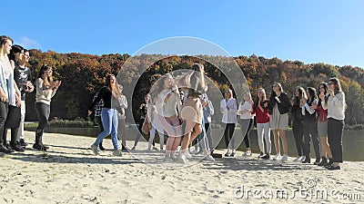 Group of People on the Sandy Beach of the Lake Performs Various Dances ...