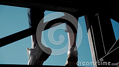 The Guy is Sitting with His Legs Dangling on the Edge of the Bridge at ...