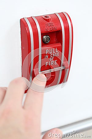 The hand of man is pulling fire alarm
