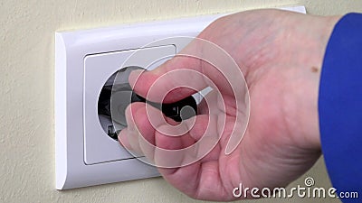 Hand Remove Safety Plug from Electricity Outlet and Insert Charger ...