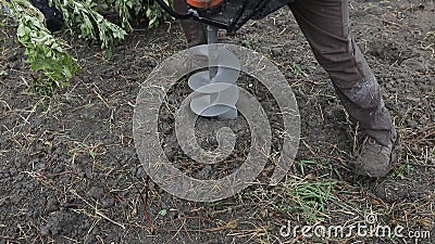 Handheld Footage with a Man Using a Hand Held Earth Hole Drilling ...
