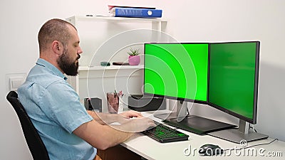 Hands of Bearded Man Typing on the Keyboard on Two Monitors with the ...