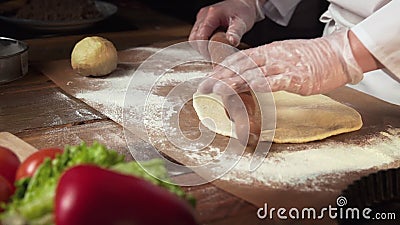 Hands of a Professional Baker Roll Out the Dough with a Rolling Pin on ...