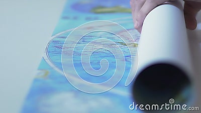 Hands Rolling Up World Map Poster and Taking it Away from the Table ...
