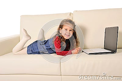 Happy Little Girl Lying On Couch Playing With Computer Stock Photo ...