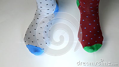 Human Legs in Fashionable Socks of Different Colors Move on White Solid ...