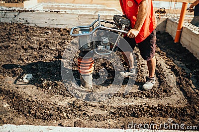 Industrial Worker Compacting Soil In House Foundation Using Compactor ...