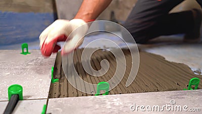 Worker Hands Placing Spacers between Ceramic Floor Tiles. Installing a ...
