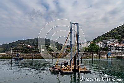 Cosntruction Workers Mount Harbor Pylons With A Floating Pile Driver In ...