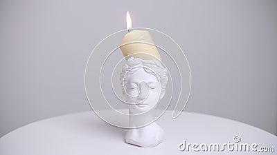 A Lit Candle in a Candlestick in the Shape of a Statue S Head Stock ...
