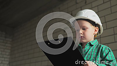 A Little Boy Builder Checks the Work Done According To the Plan of the ...