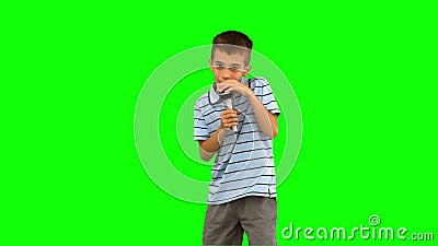 Little Boy Holding a Microphone and Singing on Green Screen Stock ...