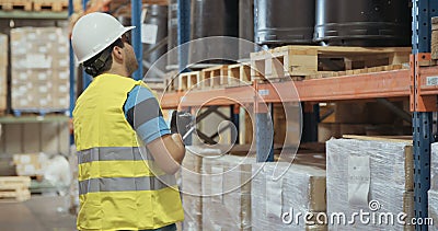 Logistics Worker Inspecting Items in a Large Warehouse Stock Footage ...