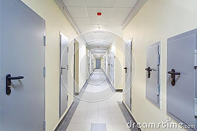 Long Yellow Hallway With Grey Metal Doors And Floor Royalty Free Stock ...
