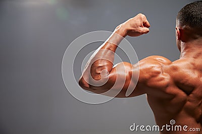 Male Bodybuilder Flexing Bicep, Back View With Copy Space Royalty-Free ...