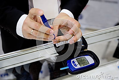 Man Pricking A Finger For Measuring Glucose Level In His Blood Drop By ...