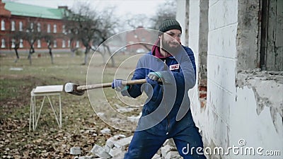 A Side View of a Worker Smashing a Wall with a Sledgehammer. Some Parts ...