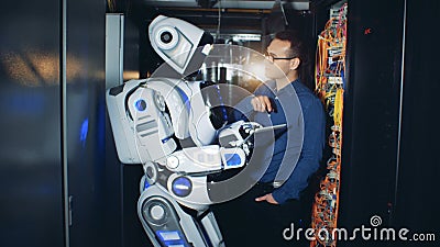 Engineer Works with a Robot in a Server Room, Close Up. Stock Video ...