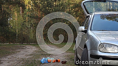 A Man Throws Away Waste, Garbage, Plastic from the Trunk of the Car ...