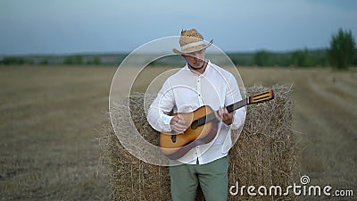 Man Wearing a Straw Hat Playing the Guitar about a Haystack Stock ...