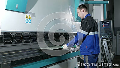 Man Working with Sheet Metal on CNC Hydraulic Press Brake. he Puts the ...