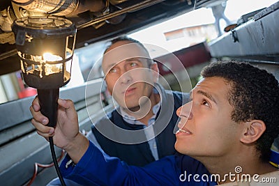 Mechanics Using Torch To Look Under Car At Repair Garage Stock Photo ...