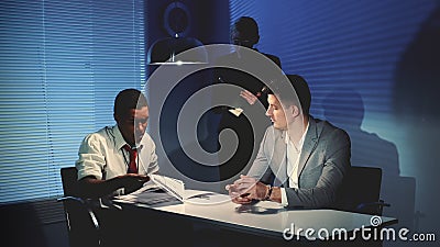 Medium Shot of African Detective Questioning Suspect Caucasian Man in ...