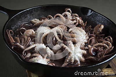 Mini Octopus In The Process Of Roasting On A Cast Iron Pan Royalty-Free ...