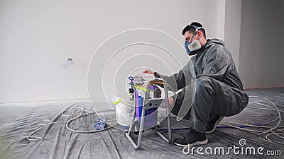 Male Builder Painter Setting Up Machine for Airless Wall Spray Painting ...