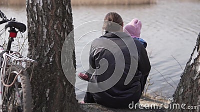 Mom and Daughter Sit by the River in the Spring on Self-isolation ...