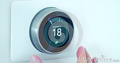 A Person Using a Smart Thermostat with a Hand Setting Lower the ...